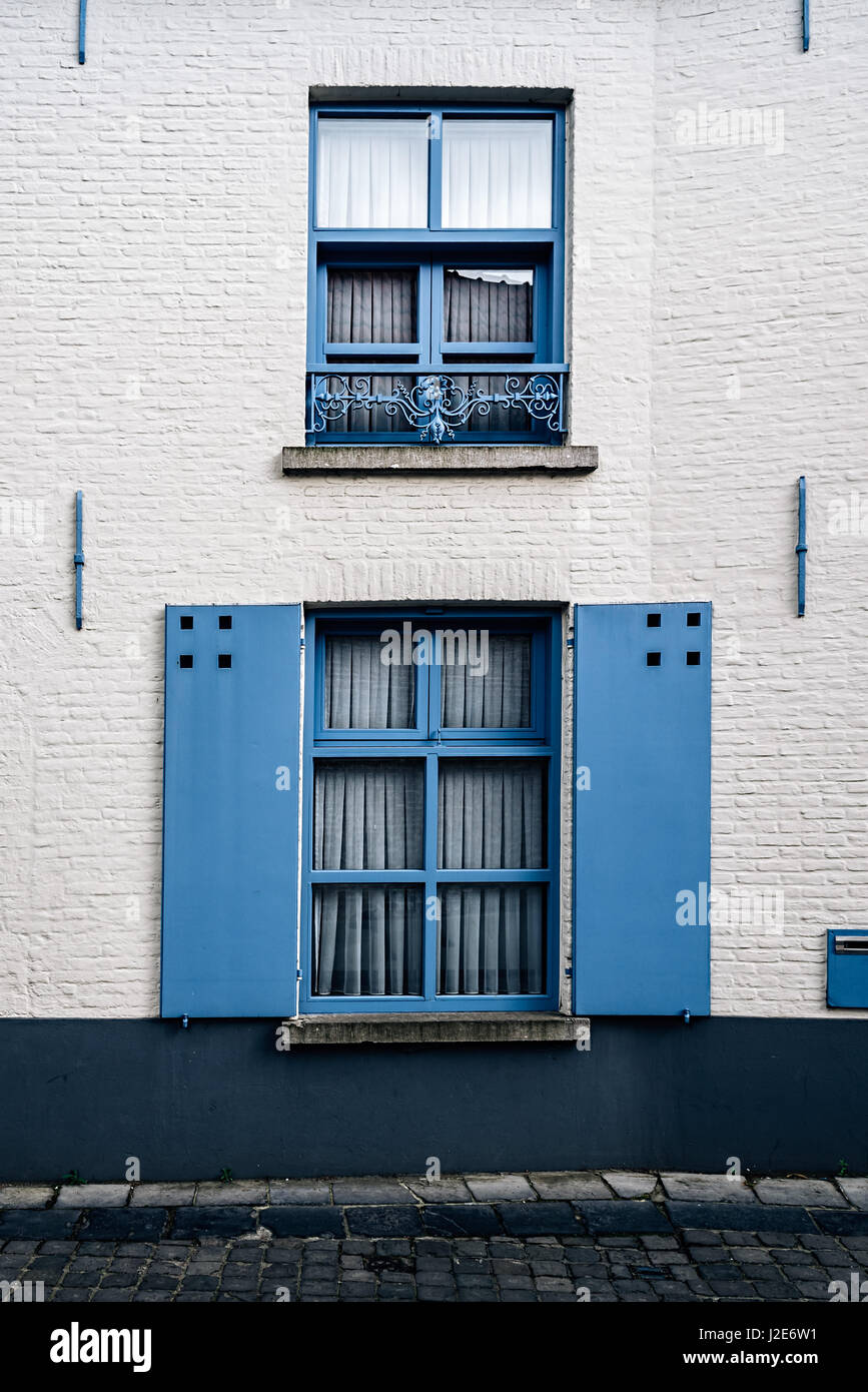 Blue wooden windows and shutters in old building with white painted ...