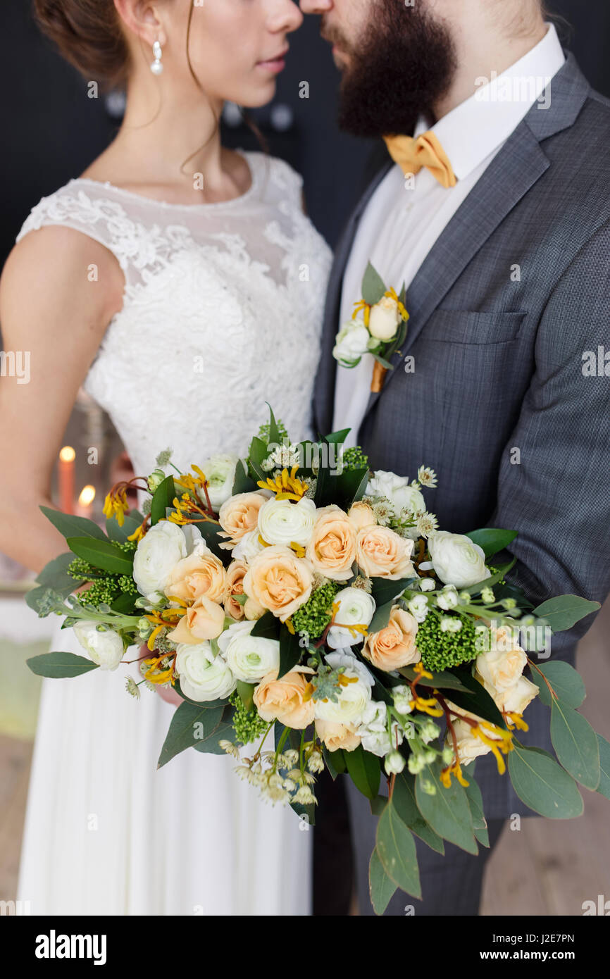 portrait of a beautiful bride with a bouquet and groom with a beard in ...