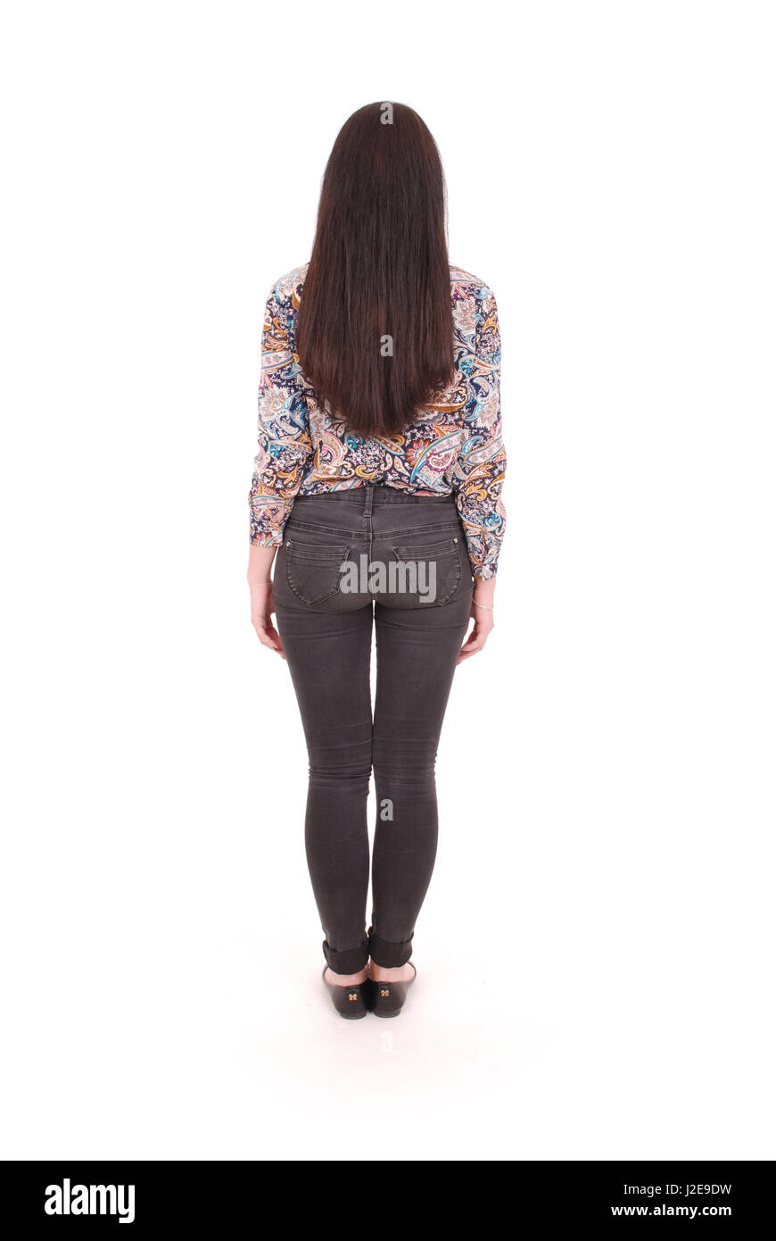 Back view of standing young beautiful woman in jeans. girl watching ...