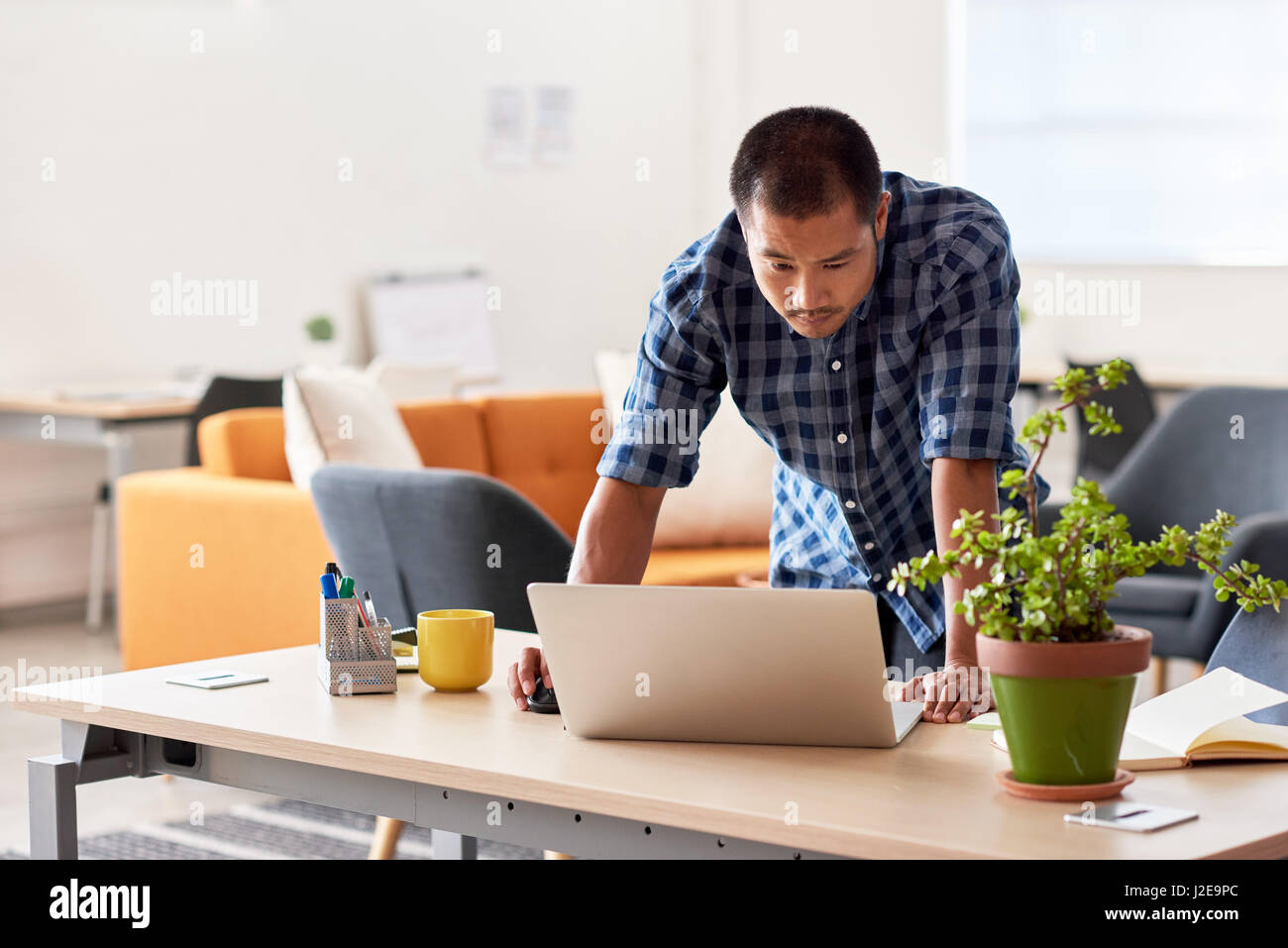 Business a man standing over a desk hi-res stock photography and images ...