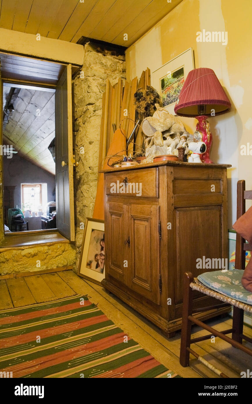 Baseboard moldings stacked upright, picture frames and dresser with red ...