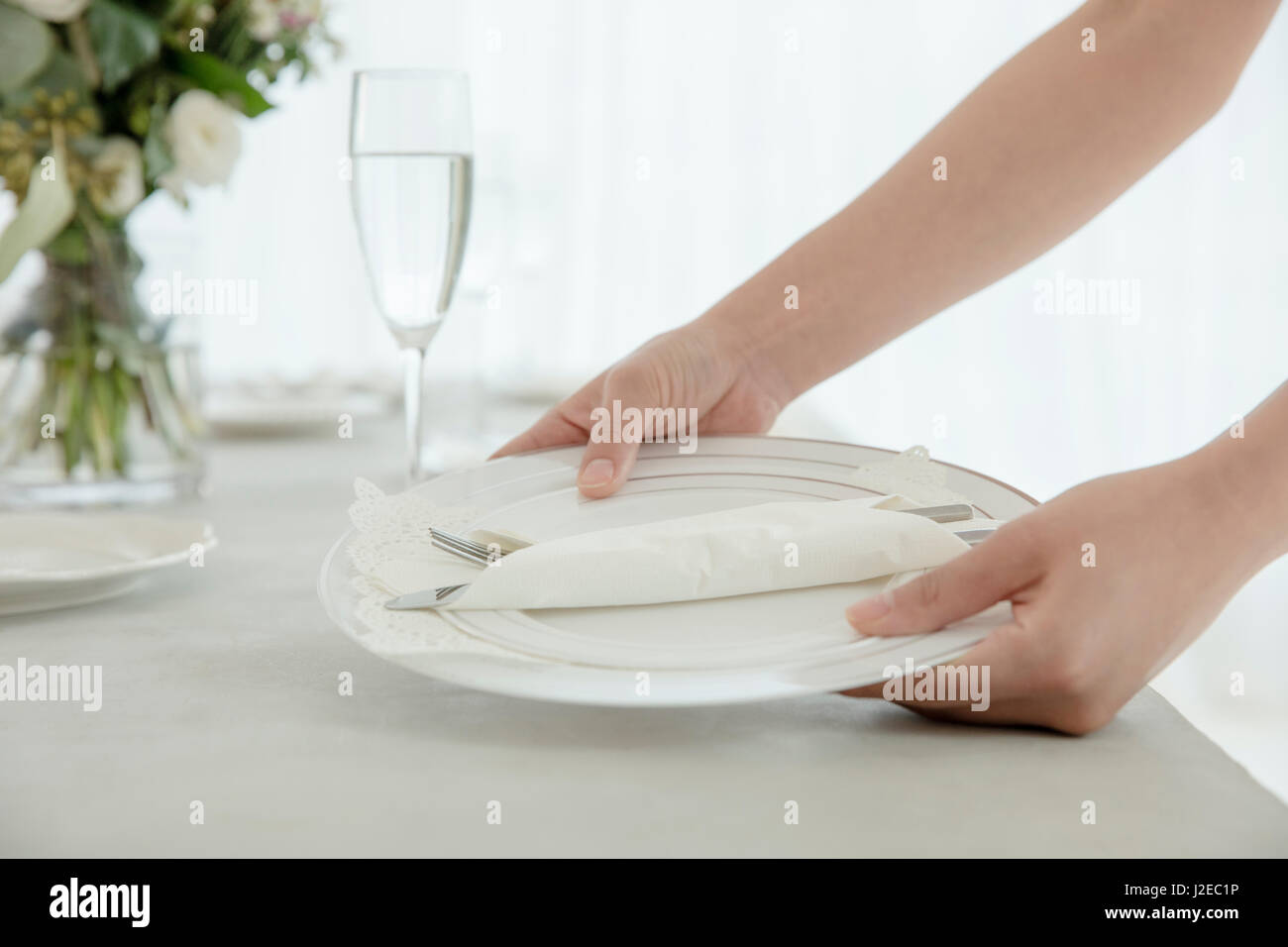 Hands setting table for party Stock Photo - Alamy