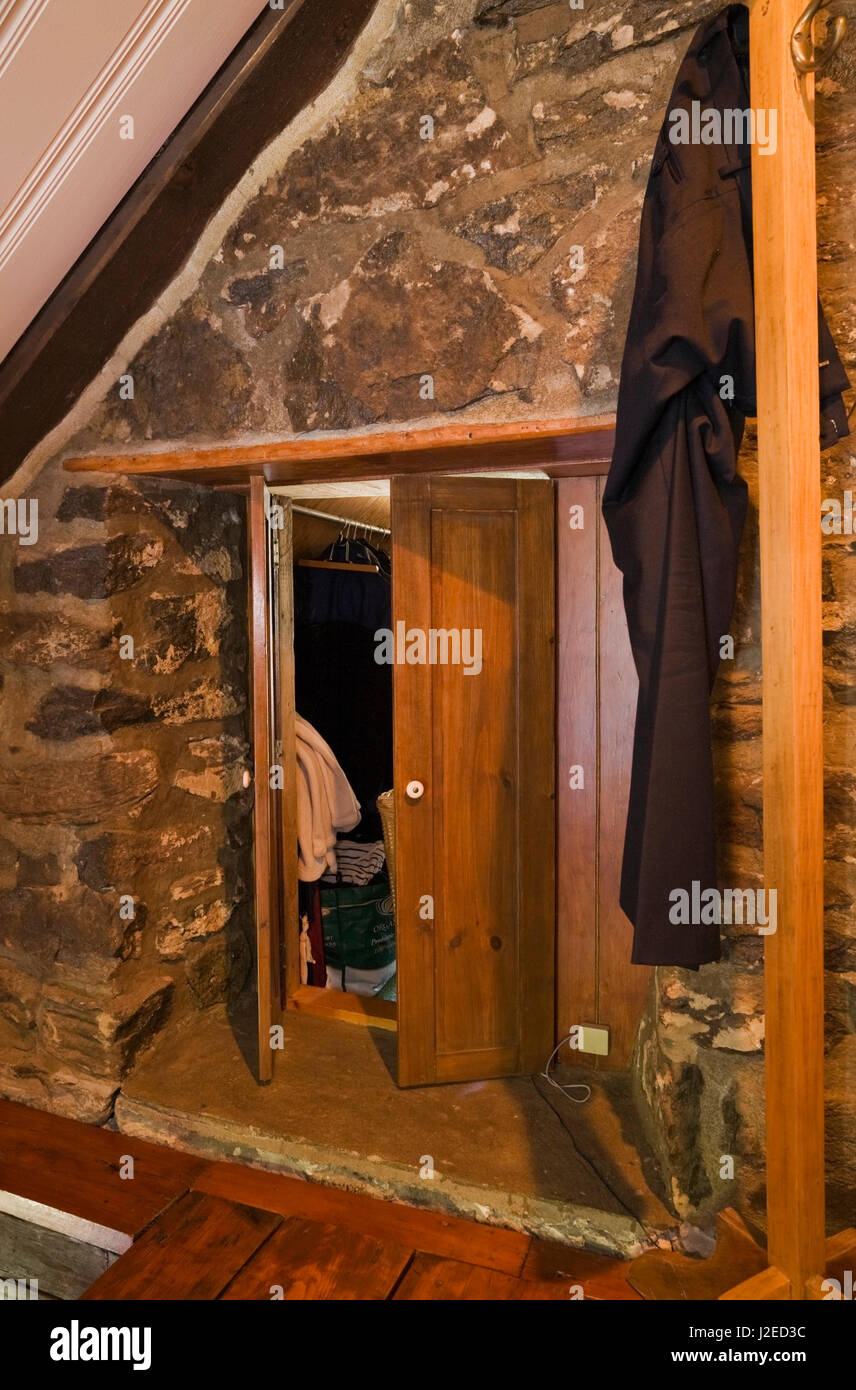 Opened wooden doors leading to small closet in the master bedroom ...