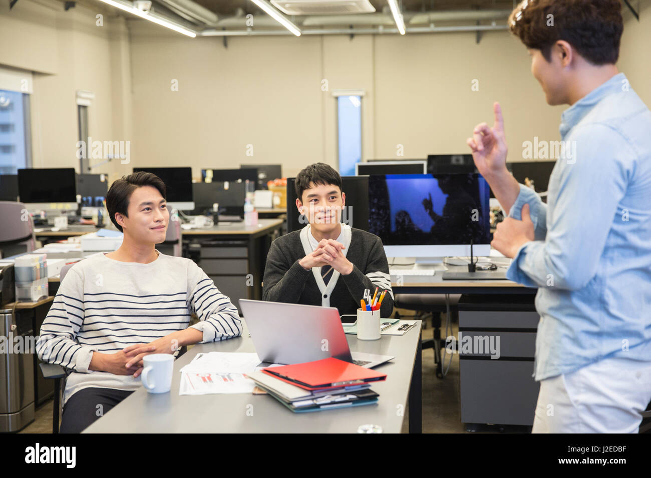 Three smiling businessmen at work Stock Photo - Alamy