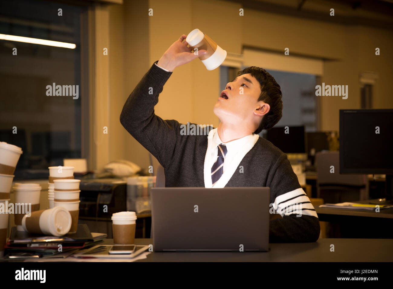 Tired businessman drinking coffee Stock Photo - Alamy
