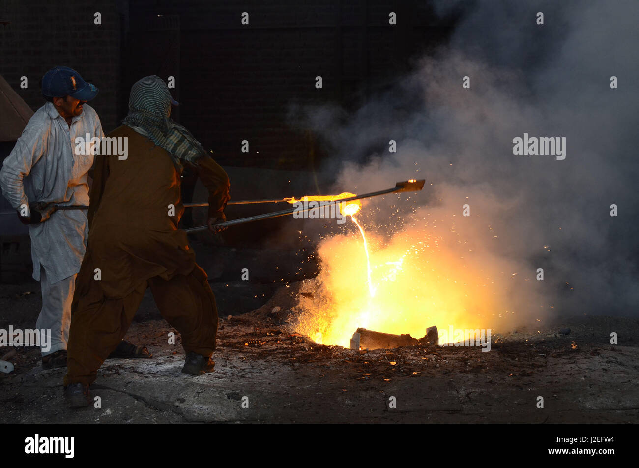 Lahore, Pakistan. 28th Apr, 2017. Pakistani laborers work by a smelter ...