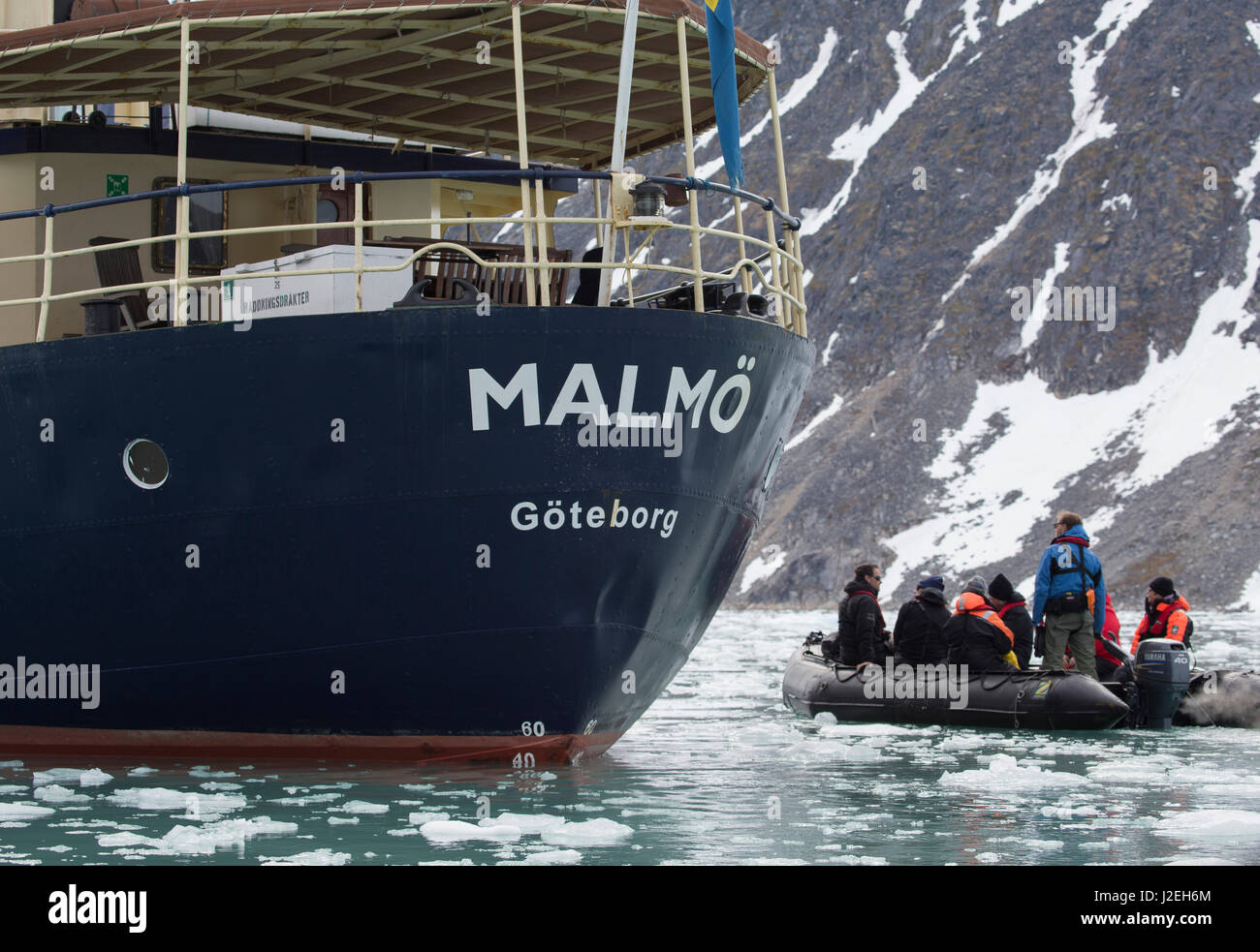 Arctic Ocean, Norway, Svalbard. People in zodiac next to ship. Credit ...
