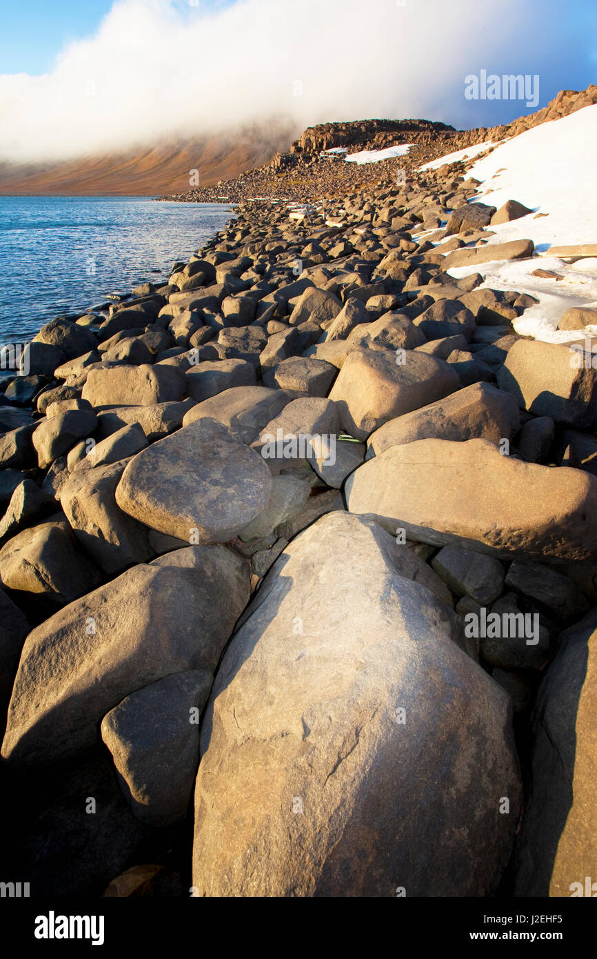 Svalbard, Barentsoya. Coastline of hard basalt boulders in the high ...