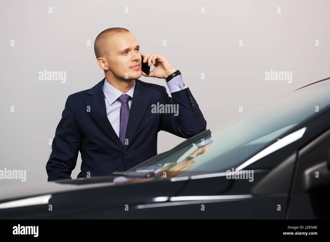 Young businessman calling on the phone at the car Stock Photo - Alamy