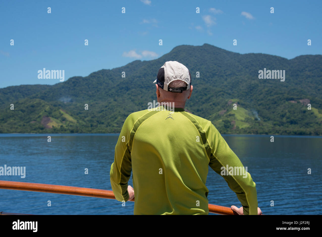 Melanesia, Papua New Guinea, Dobu Island. Male tourist looking at the ...