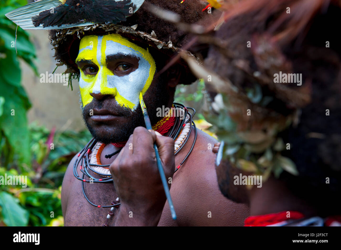 Tribesmen put up color in their face to celebrate the traditional Sing ...