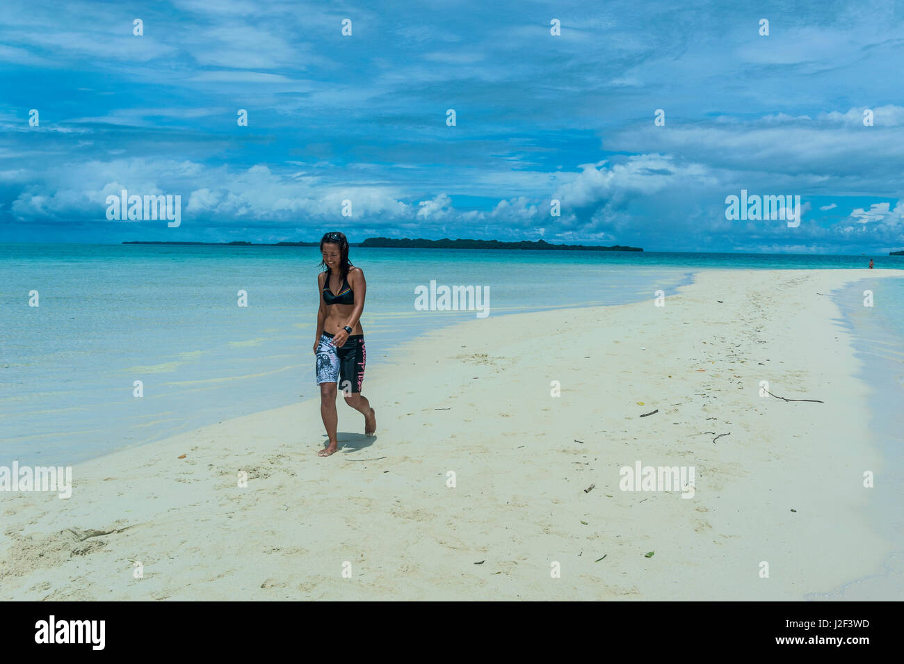 Tourist walking on a little sand strip appearing on low tide at Rock ...