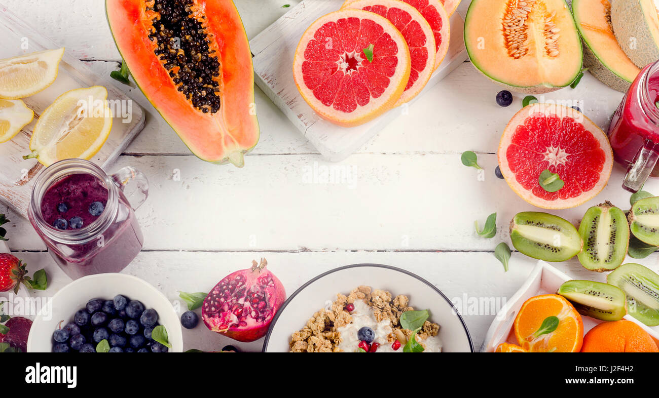 Different fruits on white wooden table. Healthy diet eating concept ...