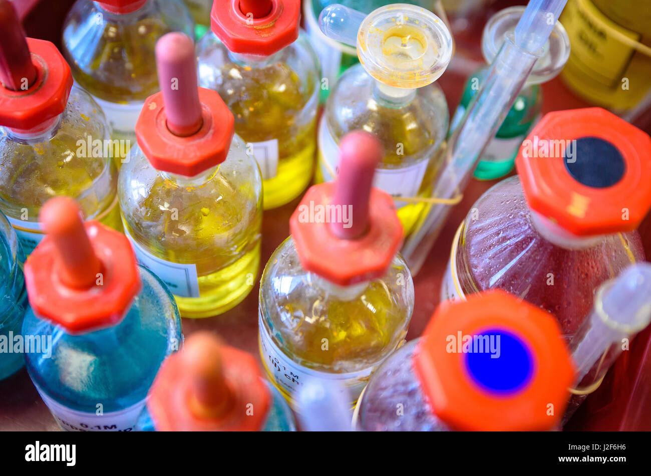 Lab bottles with teat pipettes in a variety of colours in a lab close ...