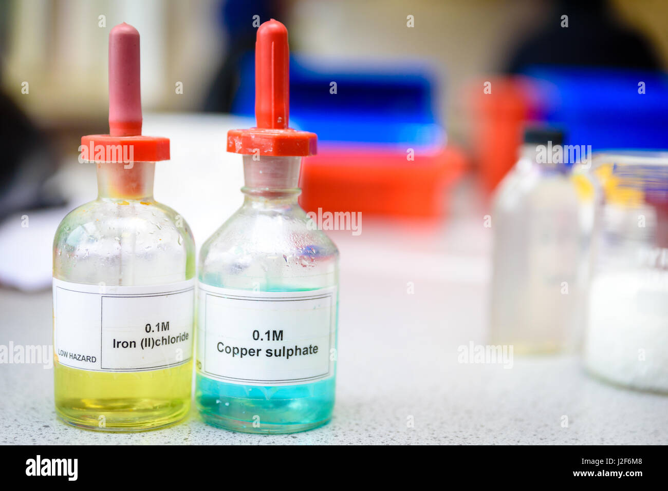 2 lab bottles with coloured chemical solutions and pipettes - close up ...