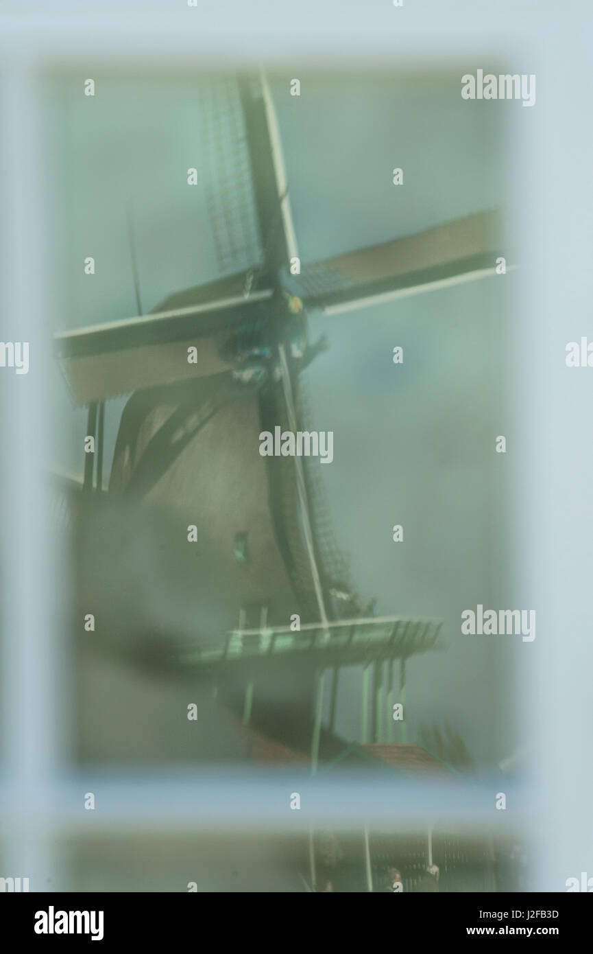 A windmill reflection in a pane of glass of a window Stock Photo - Alamy