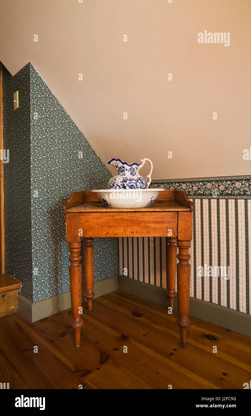Wooden wash stand with ceramic bowl and pitcher in guest bedroom on the ...