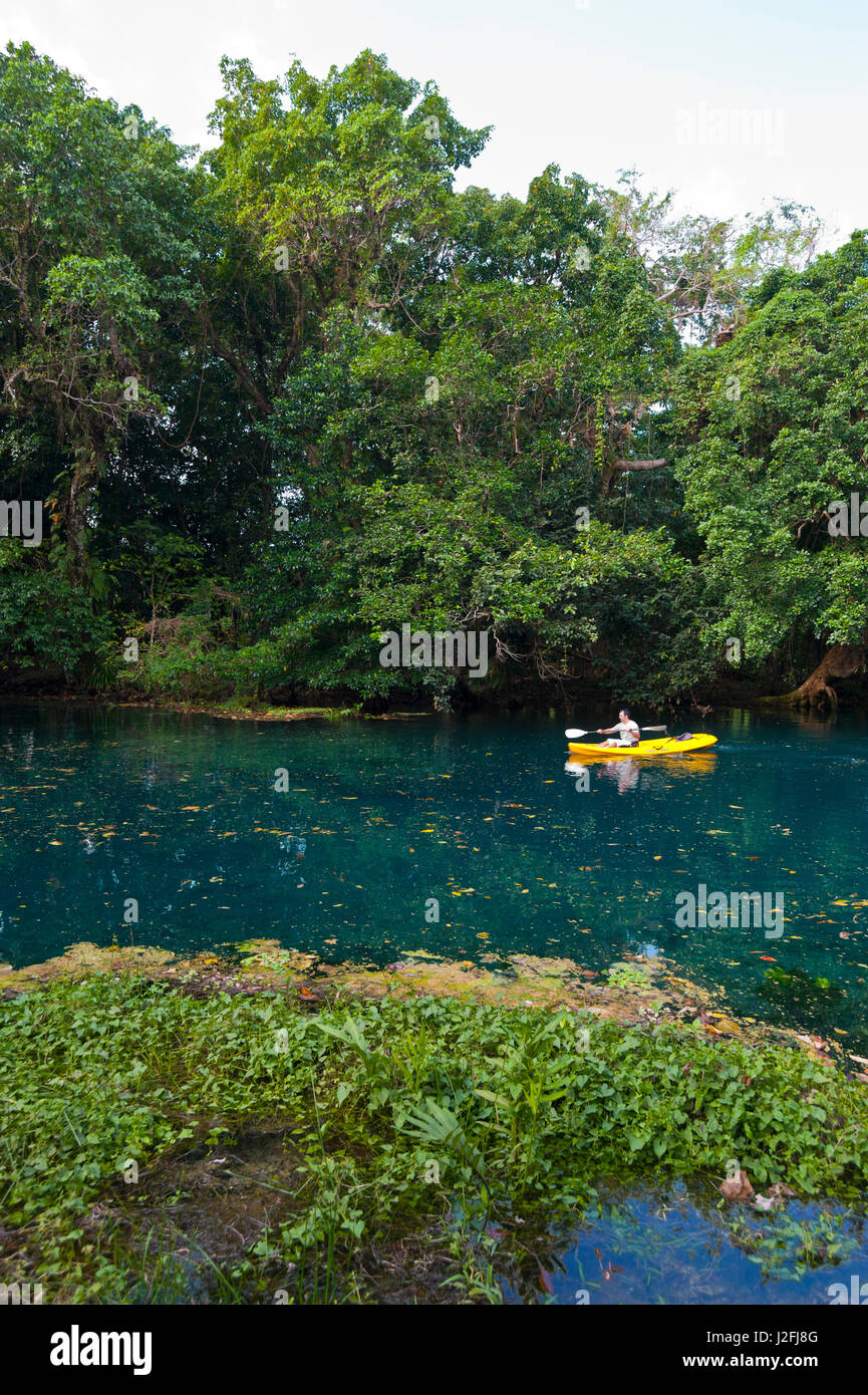 Man paddling in his kayak in the clear blue water in the Matevulu blue ...