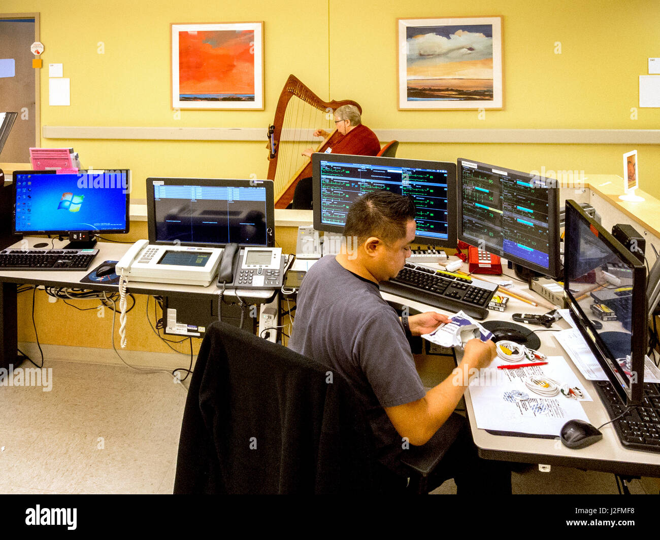 An senior woman musician plays the harp in the hallway of an Irvine, CA ...
