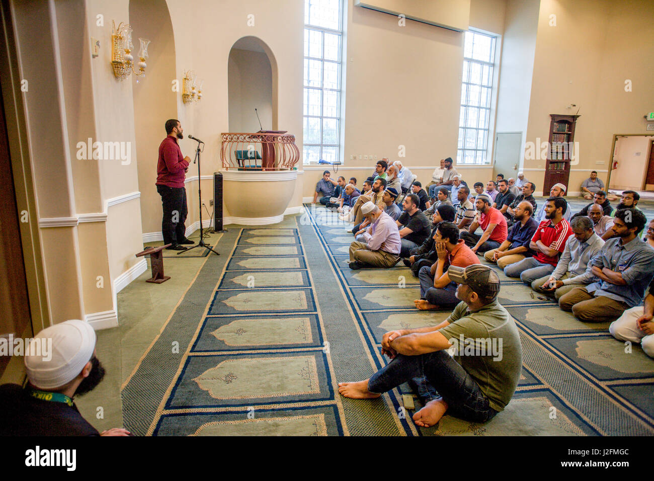 Listening to an Iman's sermon or Khutbah, Muslim men gather for Friday ...