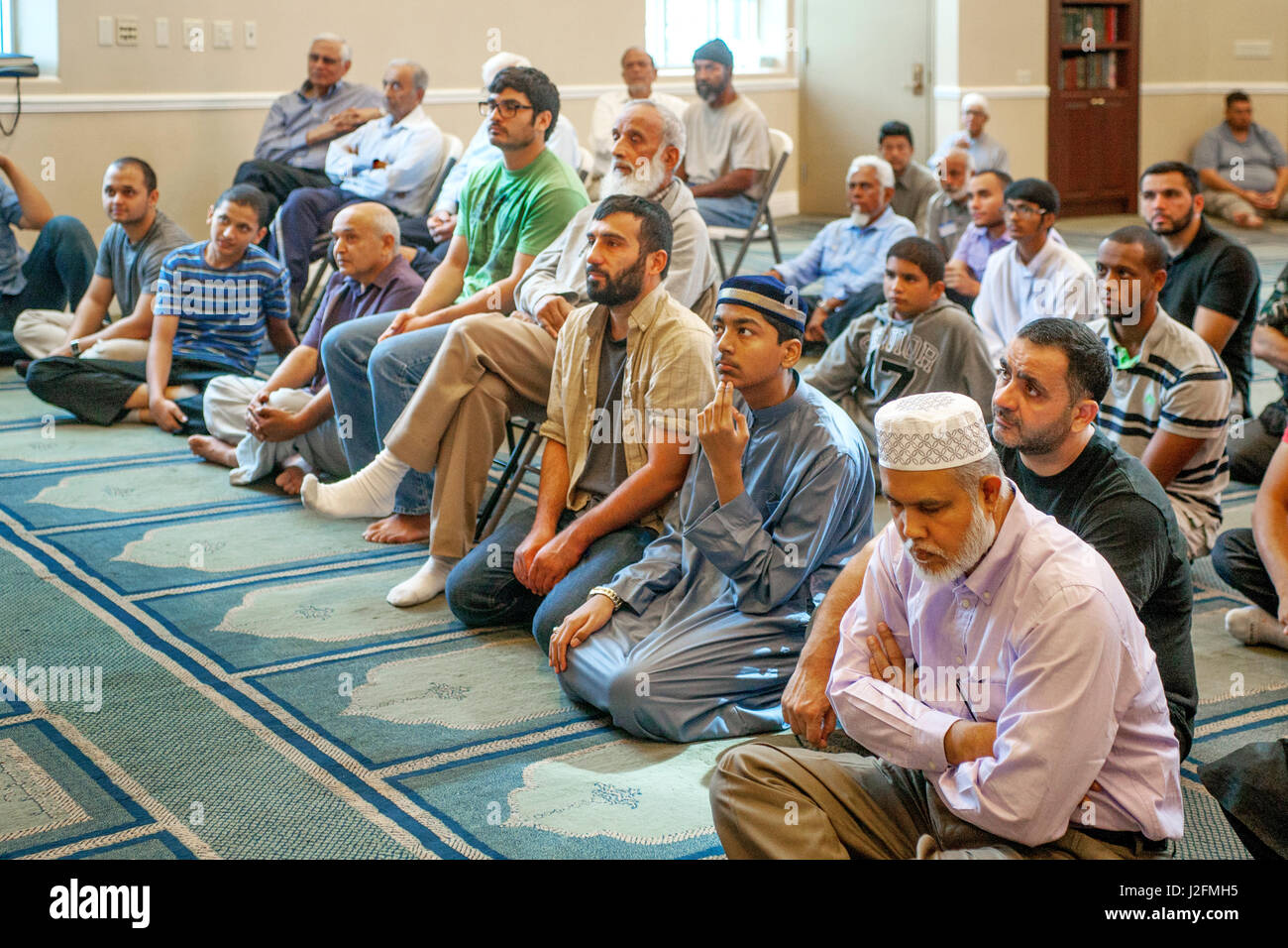 Listening to an Iman's sermon or Khutbah, Muslim men gather for Friday ...