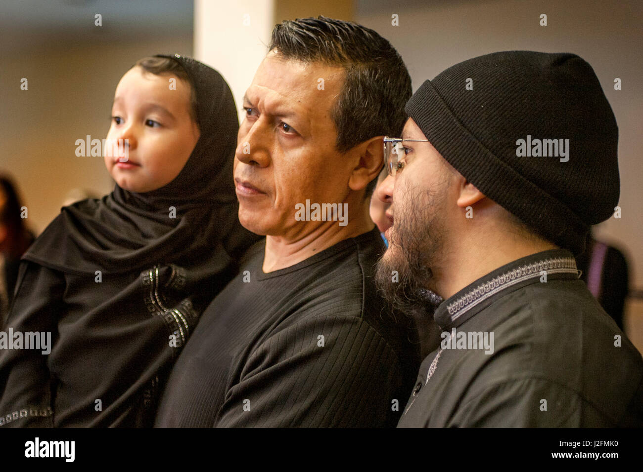 A Muslim father holds his toddler son in traditional Middle Eastern ...