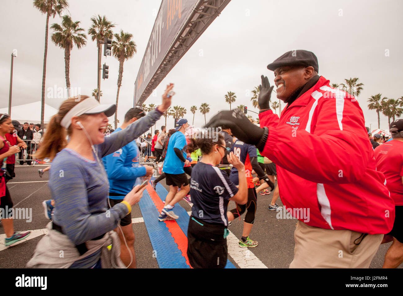 An enthusiastic spectator offers a high five to encourage a marathon ...