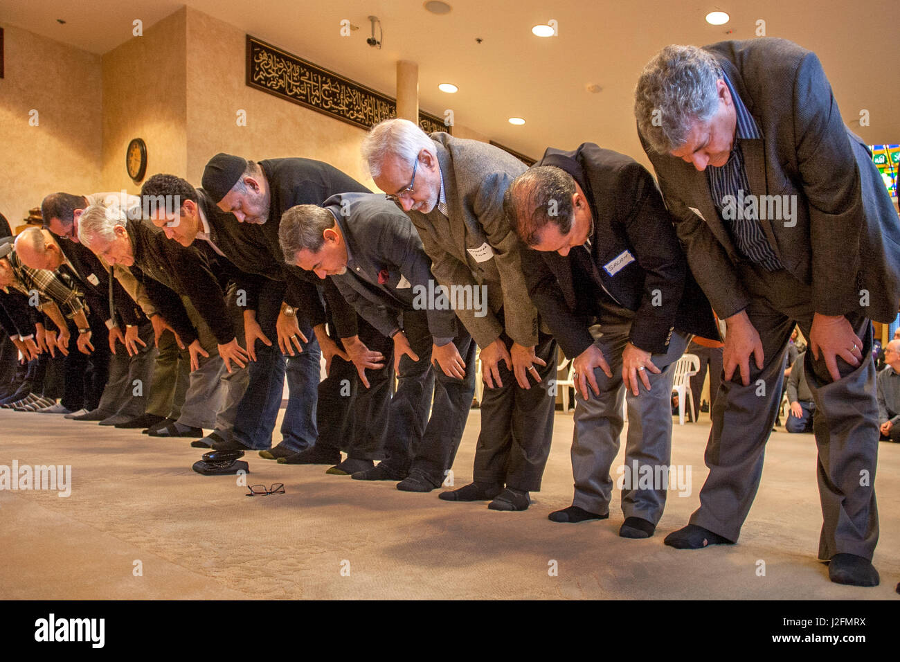 Adult men bow in prayer during religious services at a mosque in ...