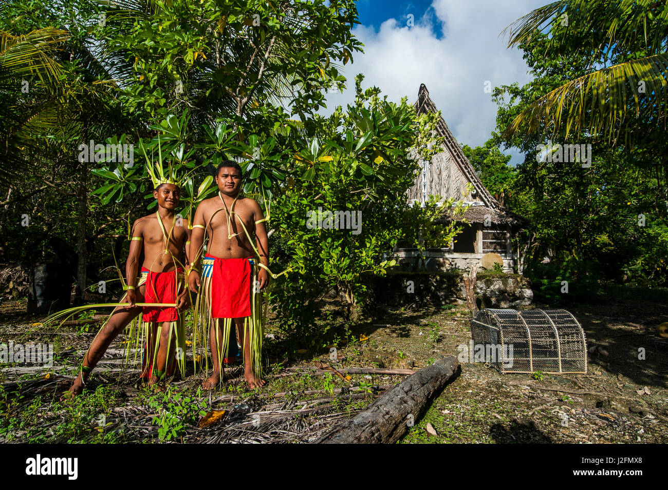 Traditional dressed men standing in front of a traditional house on the ...