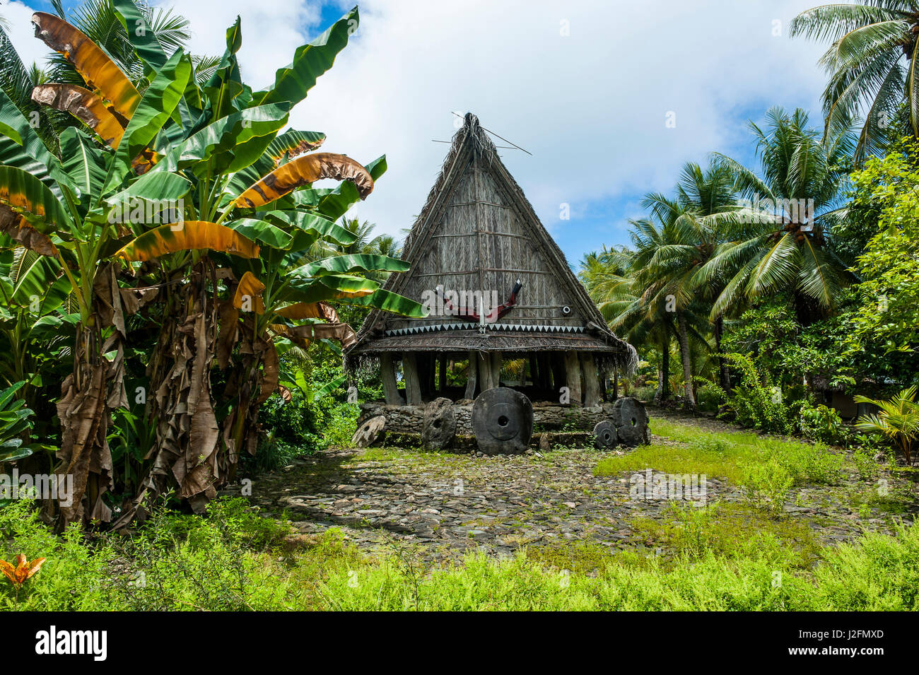 Traditional house with stone money in front, Island of Yap, Micronesia ...