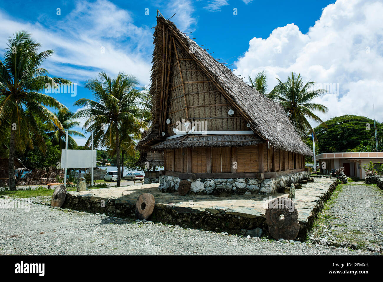 Traditional house with stone money in front, Island of Yap, Micronesia ...