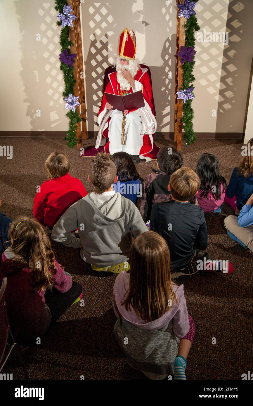 An actor costumed as Saint Nicholas and wearing a mitre reads Christmas ...