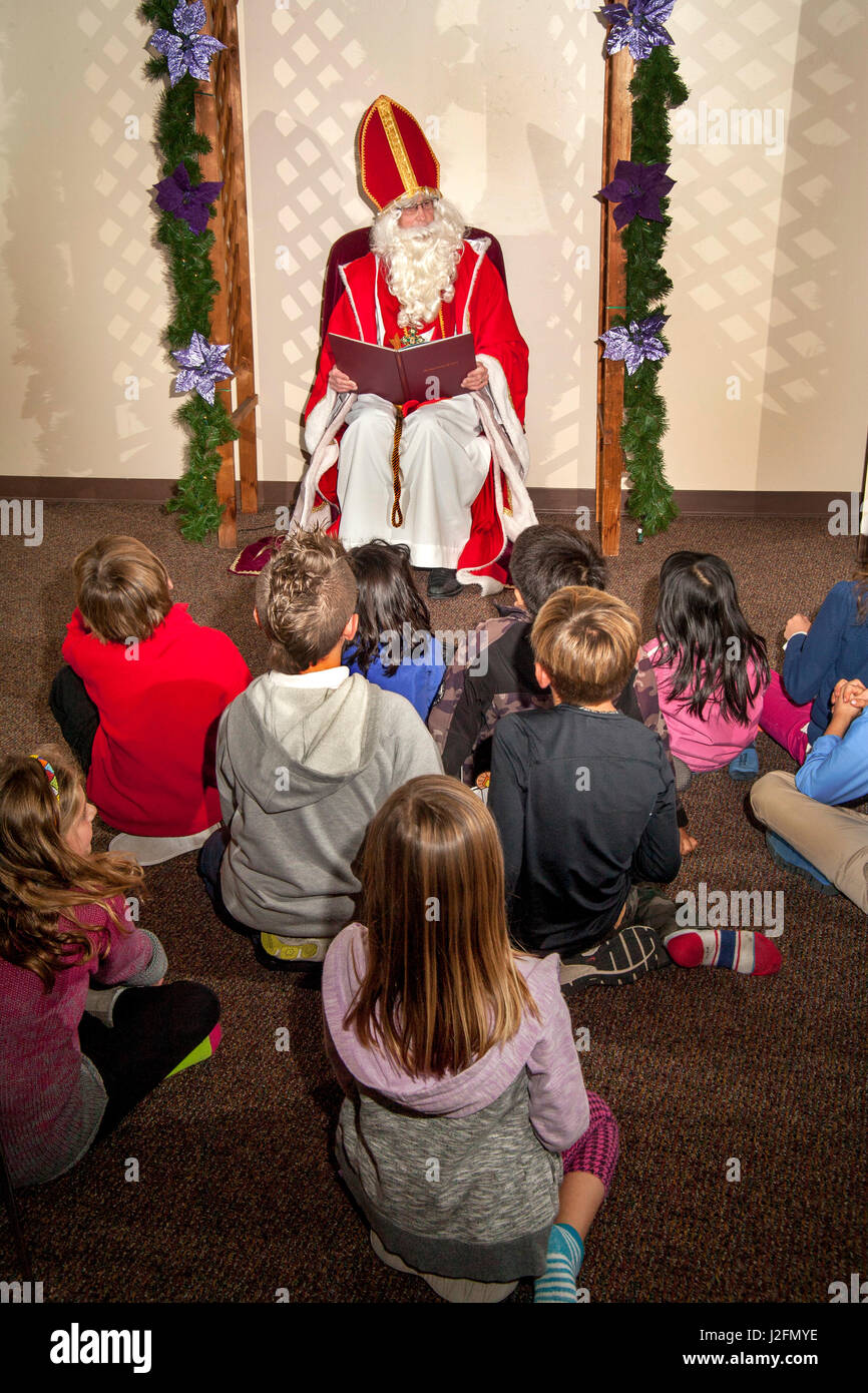 An actor costumed as Saint Nicholas and wearing a mitre reads Christmas ...