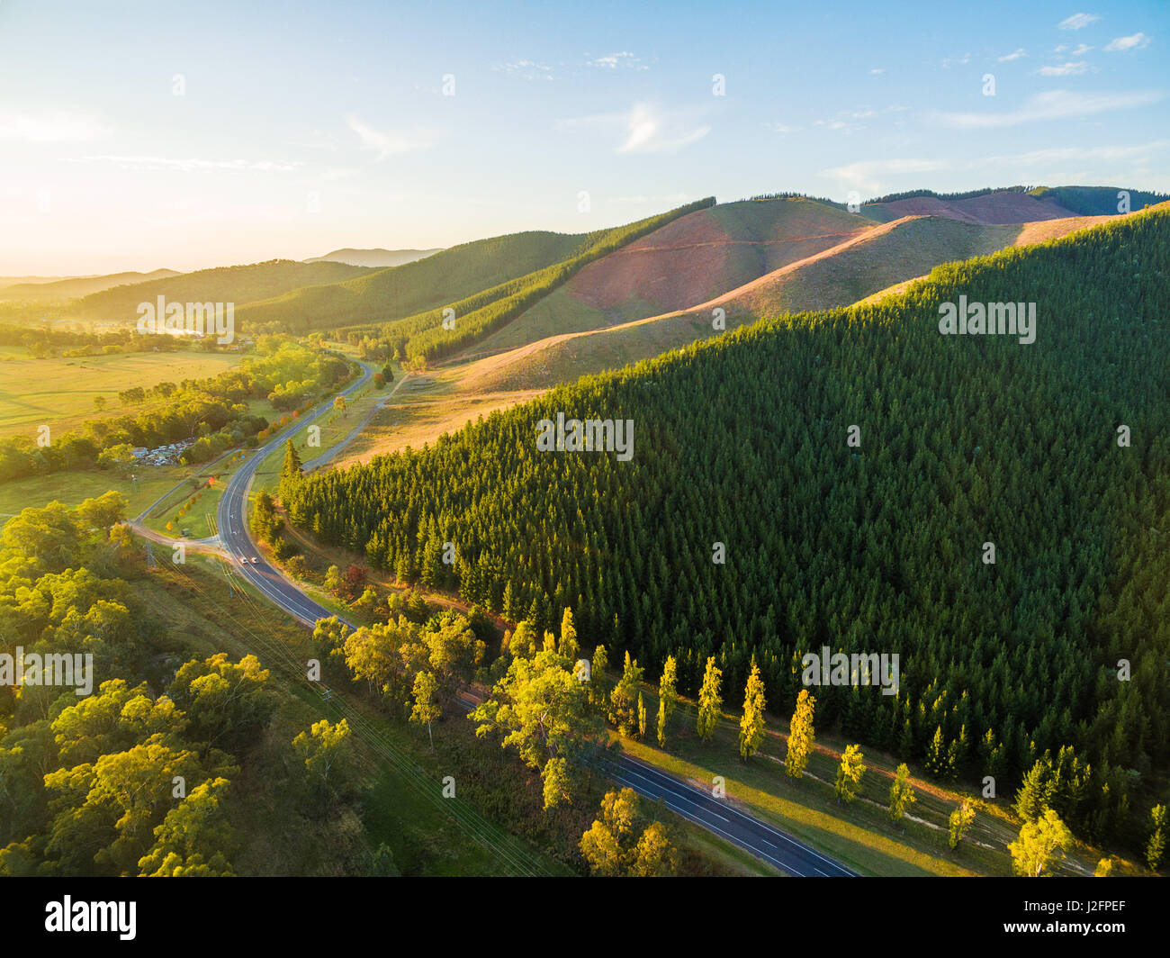 Winding road passing through beautiful Australian countryside at sunset ...