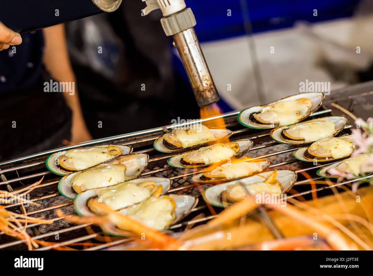 close up flame fire burn shell with cheese for serve Stock Photo - Alamy