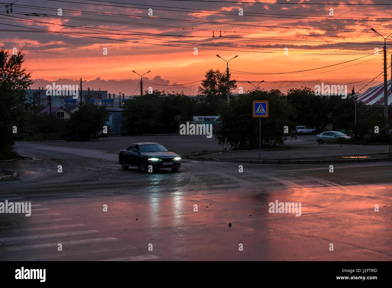 Colorful and red sunset illuminates the road in the city. Beautiful sky ...