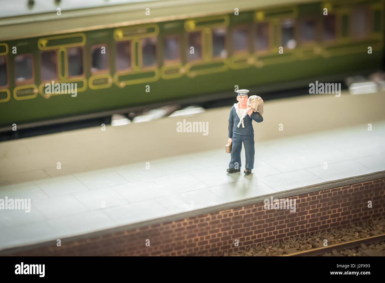 miniature model of a sailor alone on a railroad platform - shallow d.o ...