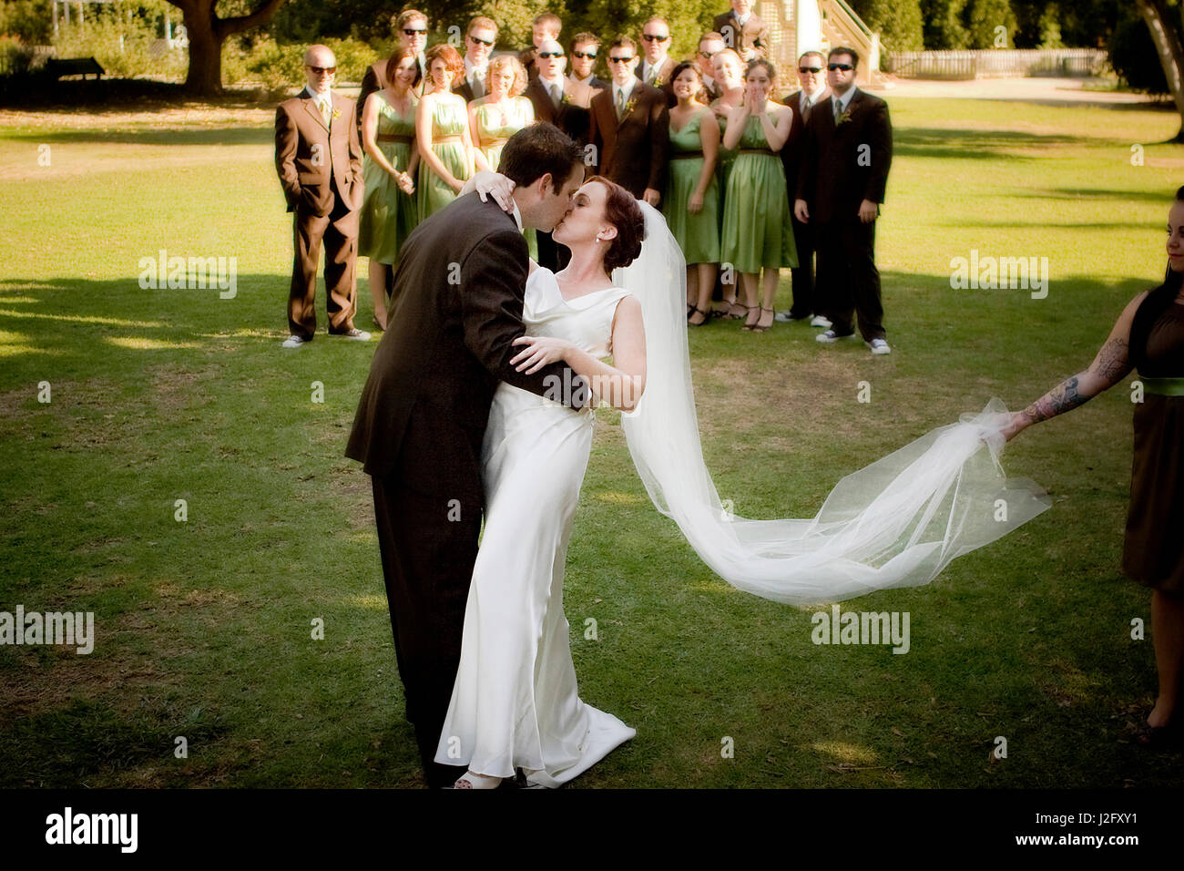 A groom sees his bride for the first time as the wedding party watches ...