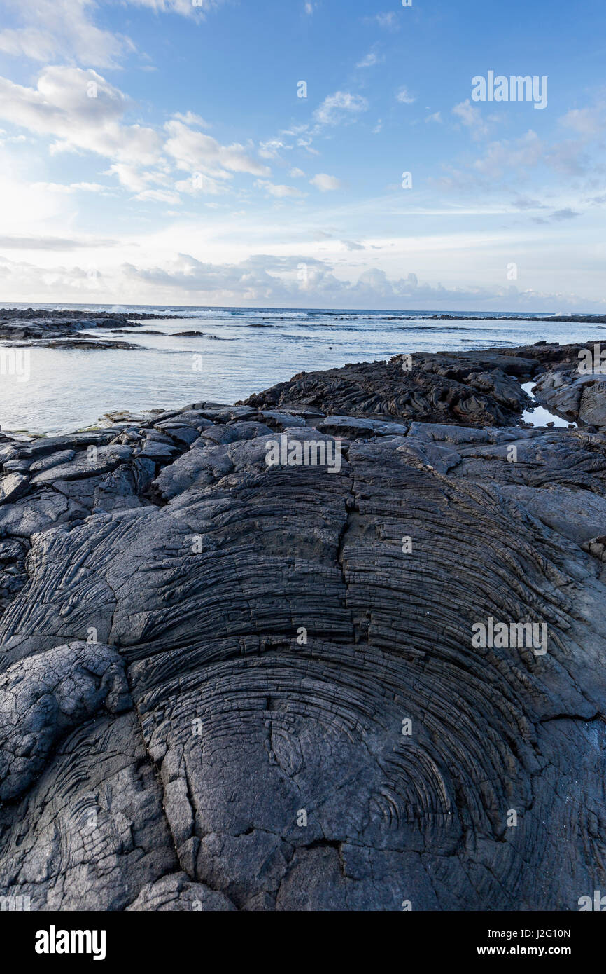 Cooled lava flow creates complex patterns along the shoreline of the ...