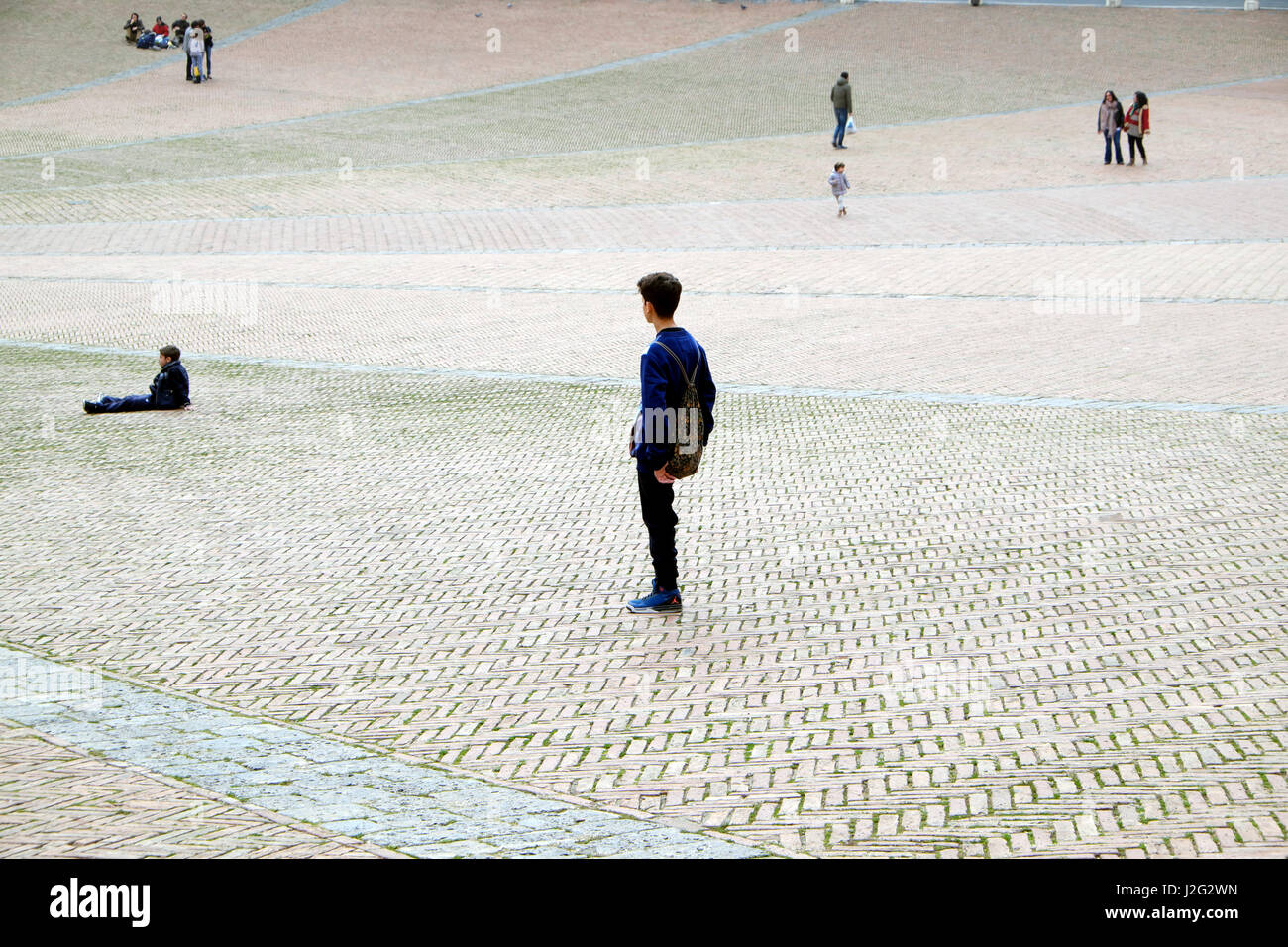 Youth - Young boys relaxing and playing in an Italian historical square ...