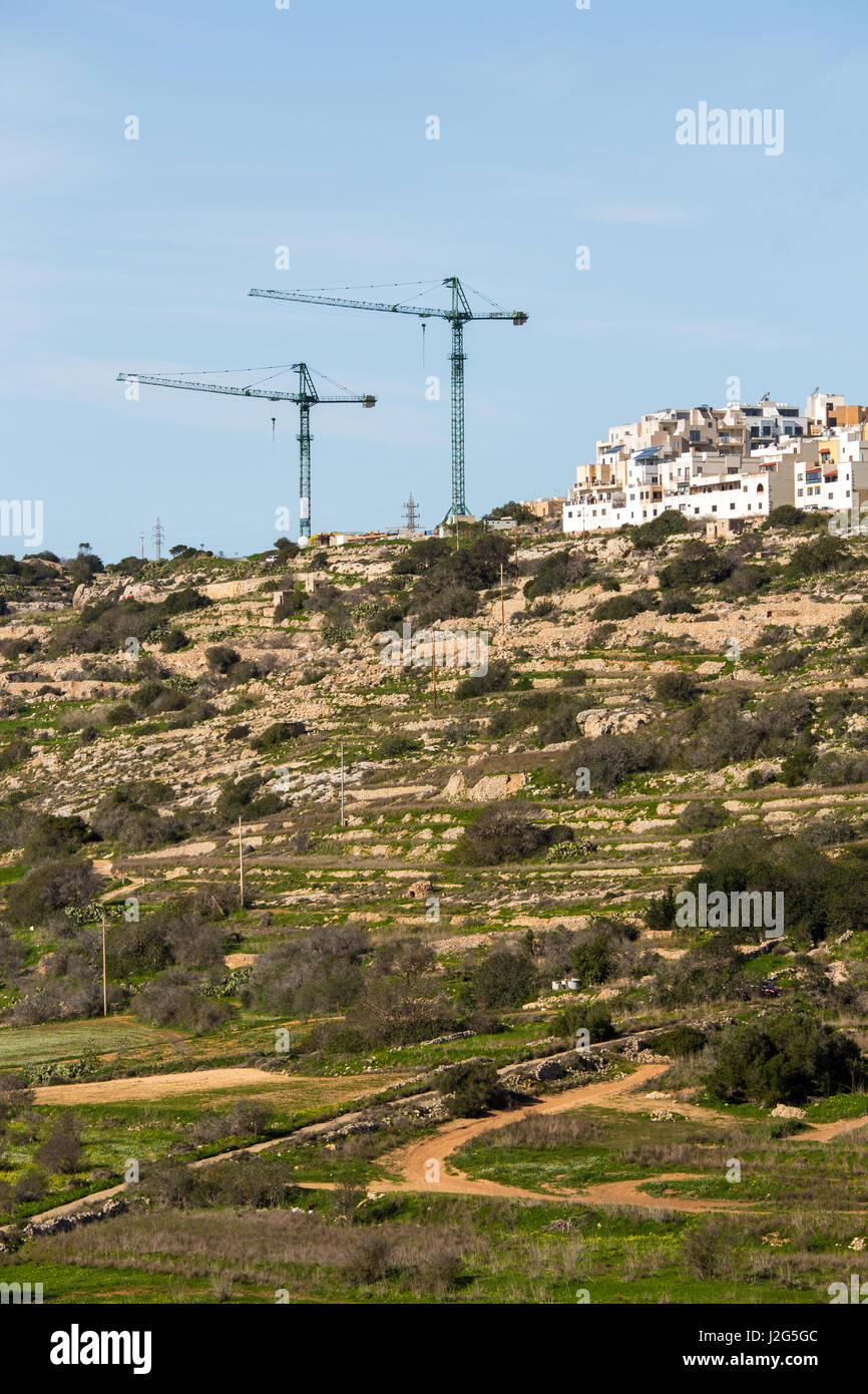 Cranes tower over Mellieha in the northern part of the island of malta ...
