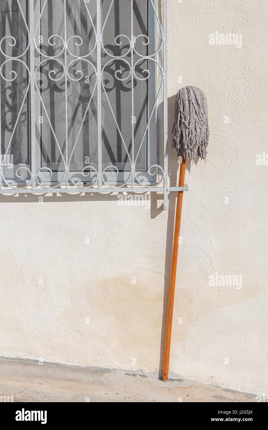 A mop stood outside a window of a house. Minimalist composition Stock ...