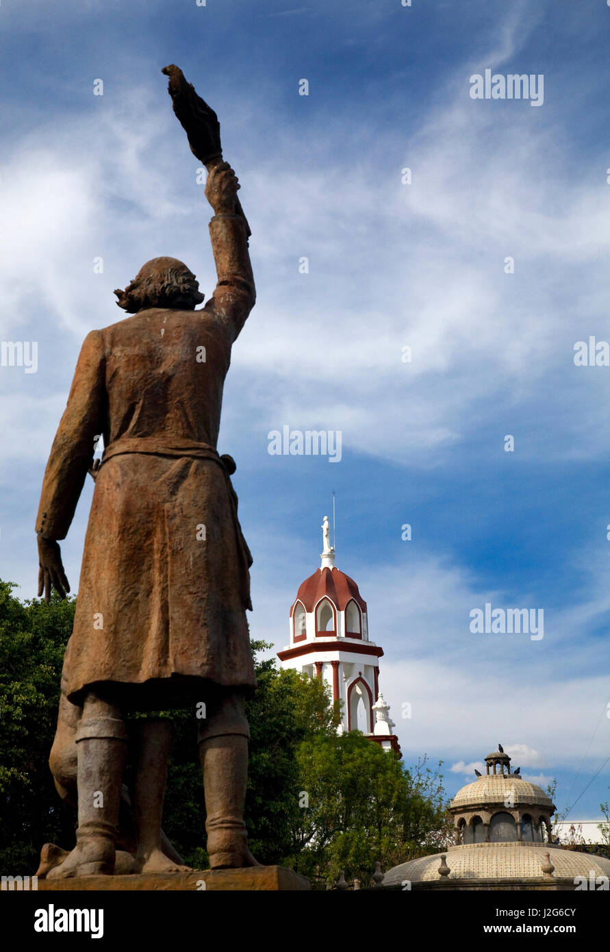 Statue of Miguel Hidalgo in public park with churches in background ...