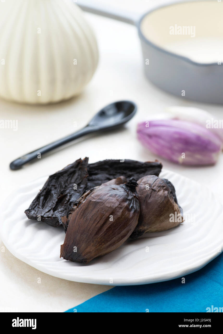 bright and colorful vertical image of black onions on a textured dish ...