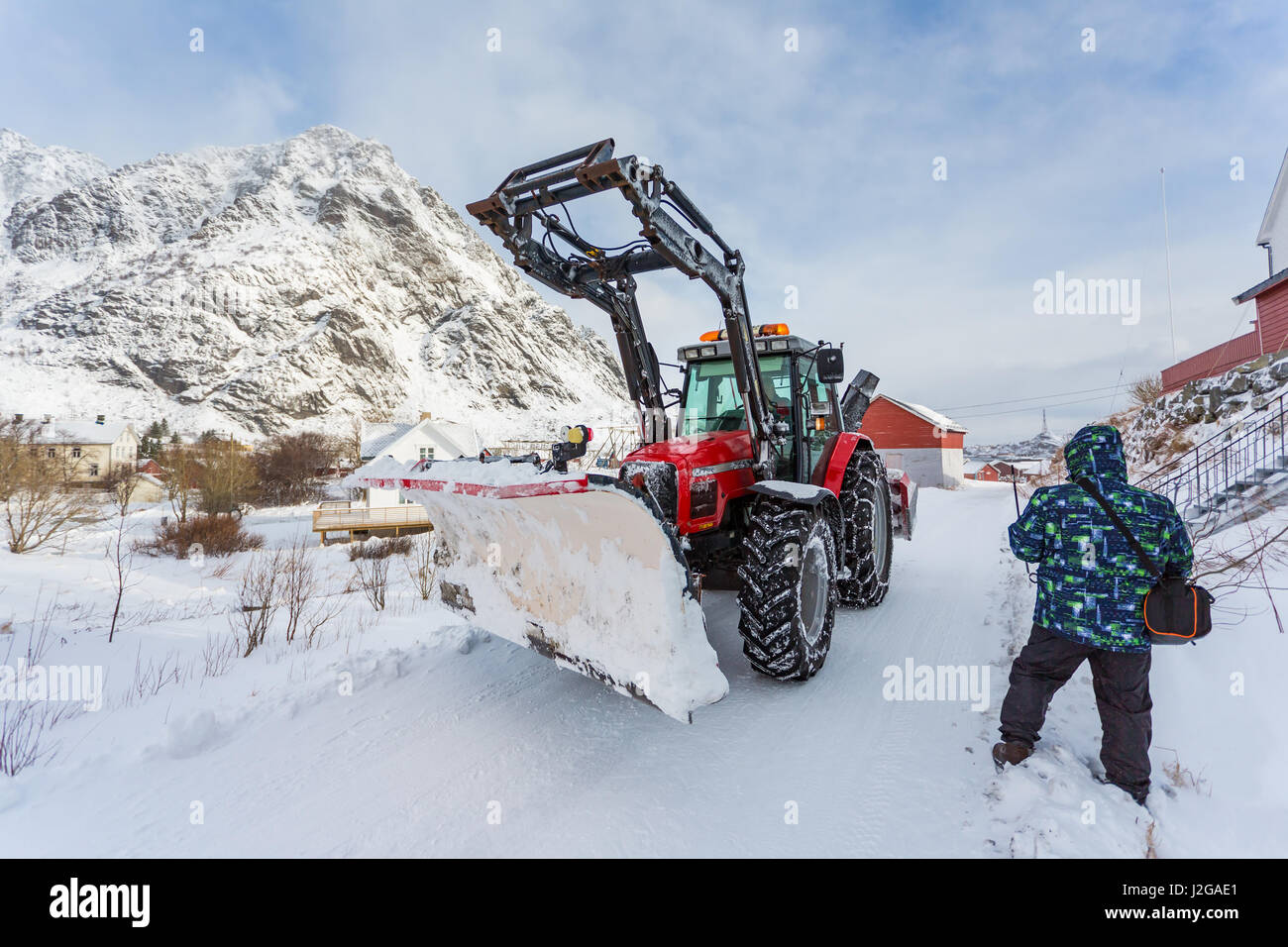 The man by the side of the road bypasses a snow-plow tractor in the ...