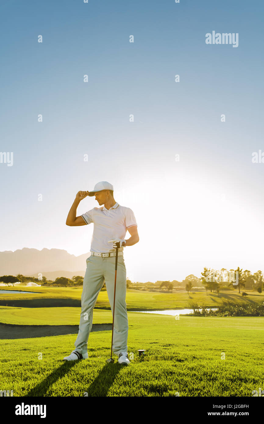 Full length of young man standing on golf course. Professional golfer ...