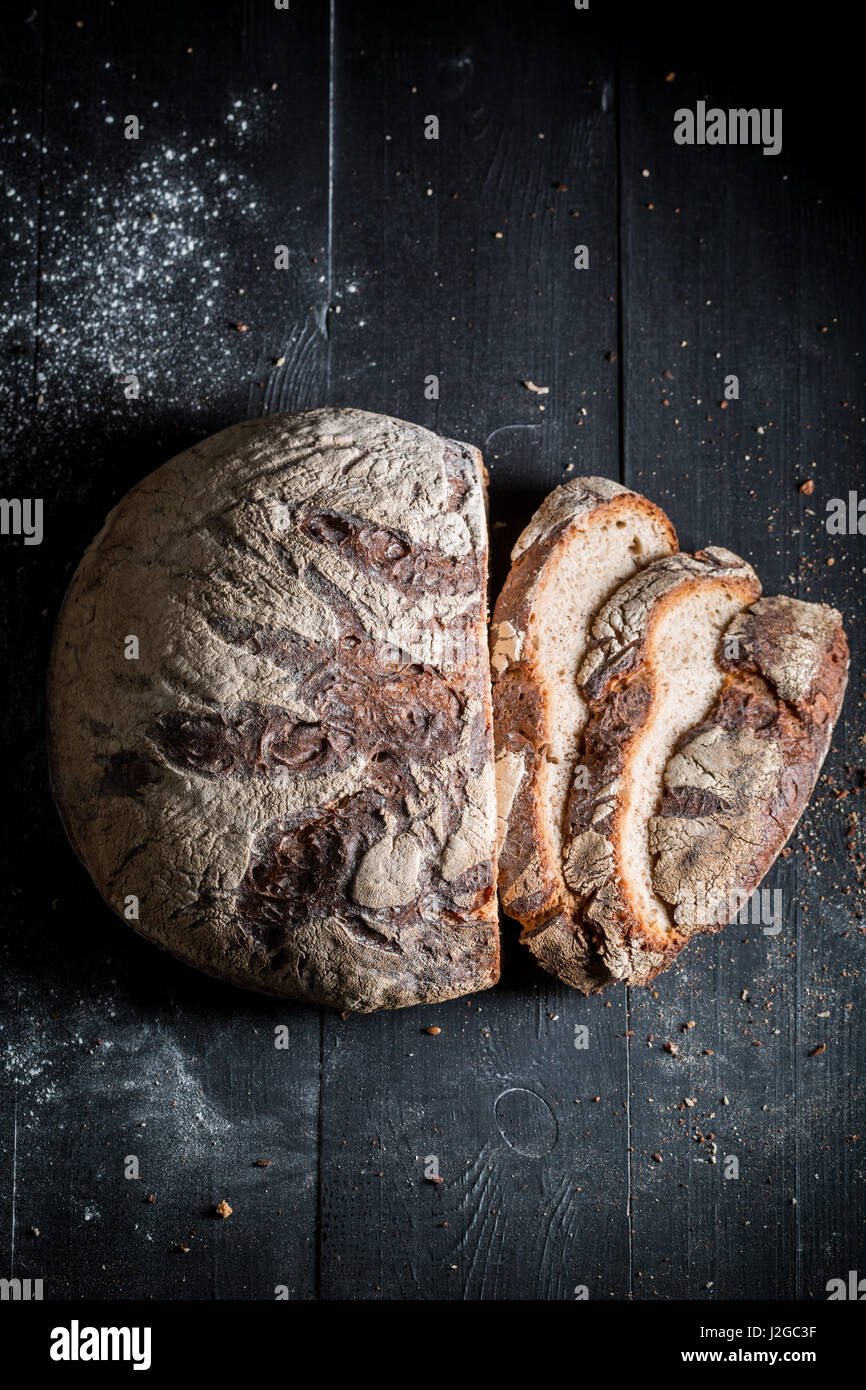 Delicious loaf of bread on dark table with flour Stock Photo - Alamy