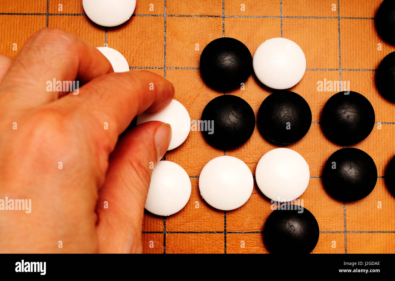 man hand playing a stone in the game of Go Stock Photo - Alamy