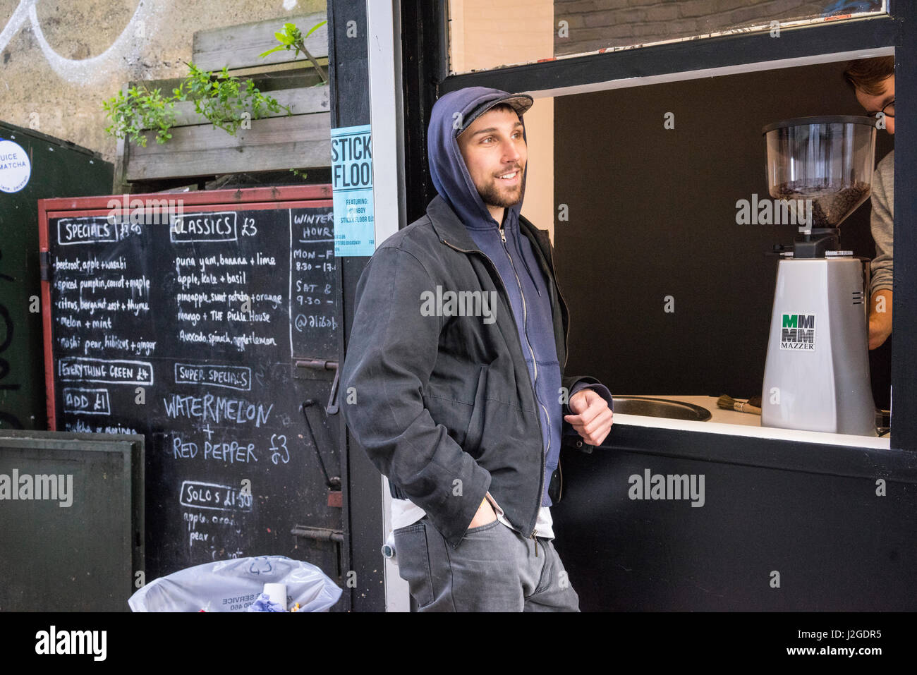 A man enjoying a coffee at a coffee shop on Rye Lane. Photographs from ...