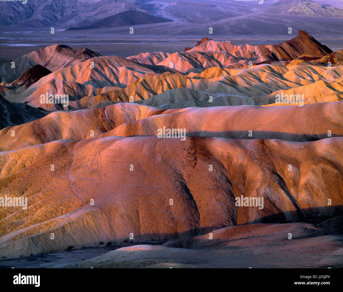 USA, California, Death Valley National Park, Sunrise light on eroded ...